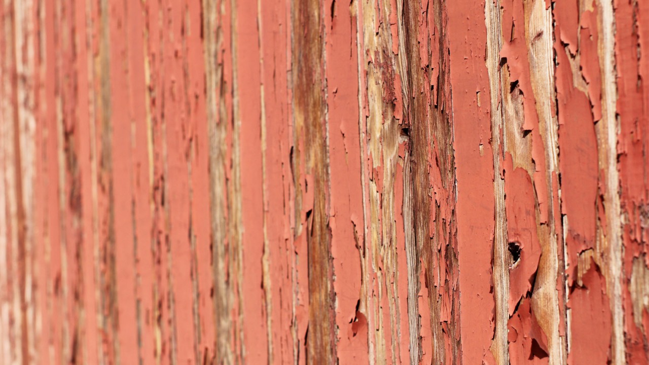 red and peeling paint from the side of a boxcar